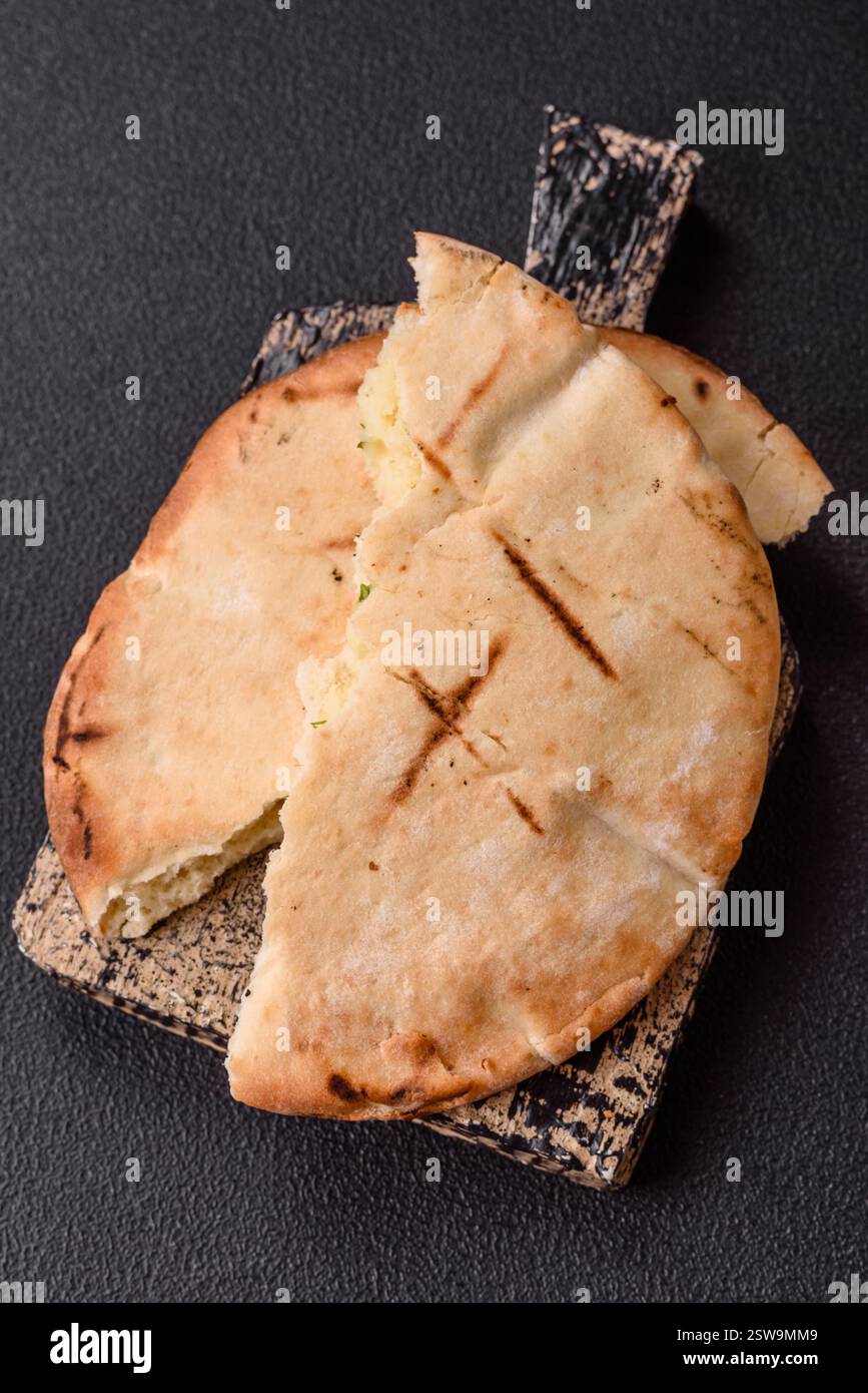 Round flatbread or pita with cheese, herbs, salt and spices Stock Photo ...