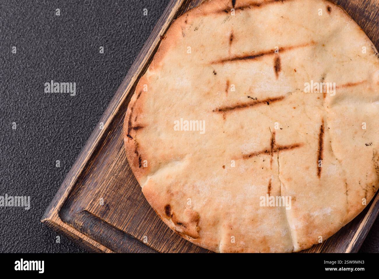 Round flatbread or pita with cheese, herbs, salt and spices Stock Photo ...