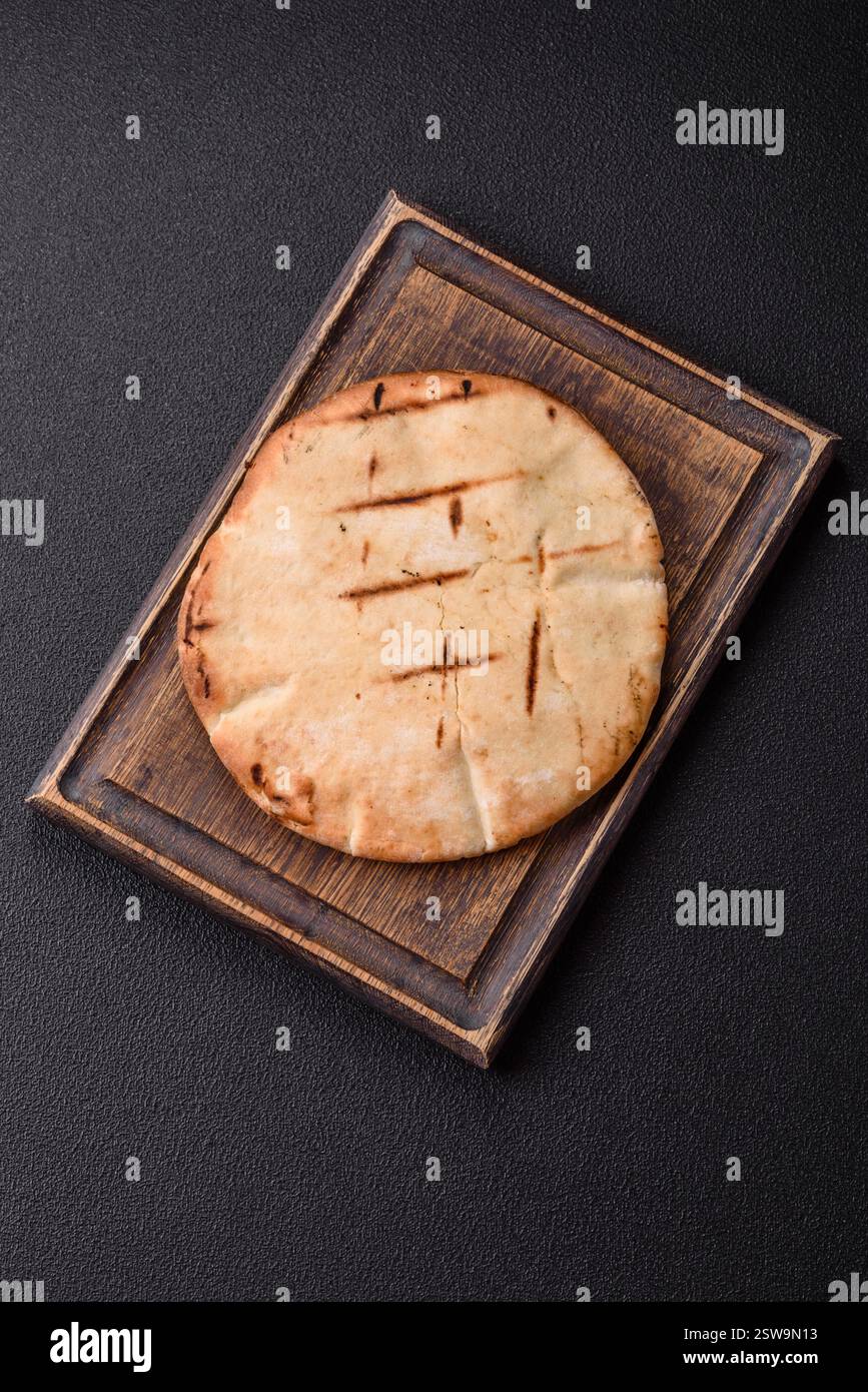 Round flatbread or pita with cheese, herbs, salt and spices, baked on ...