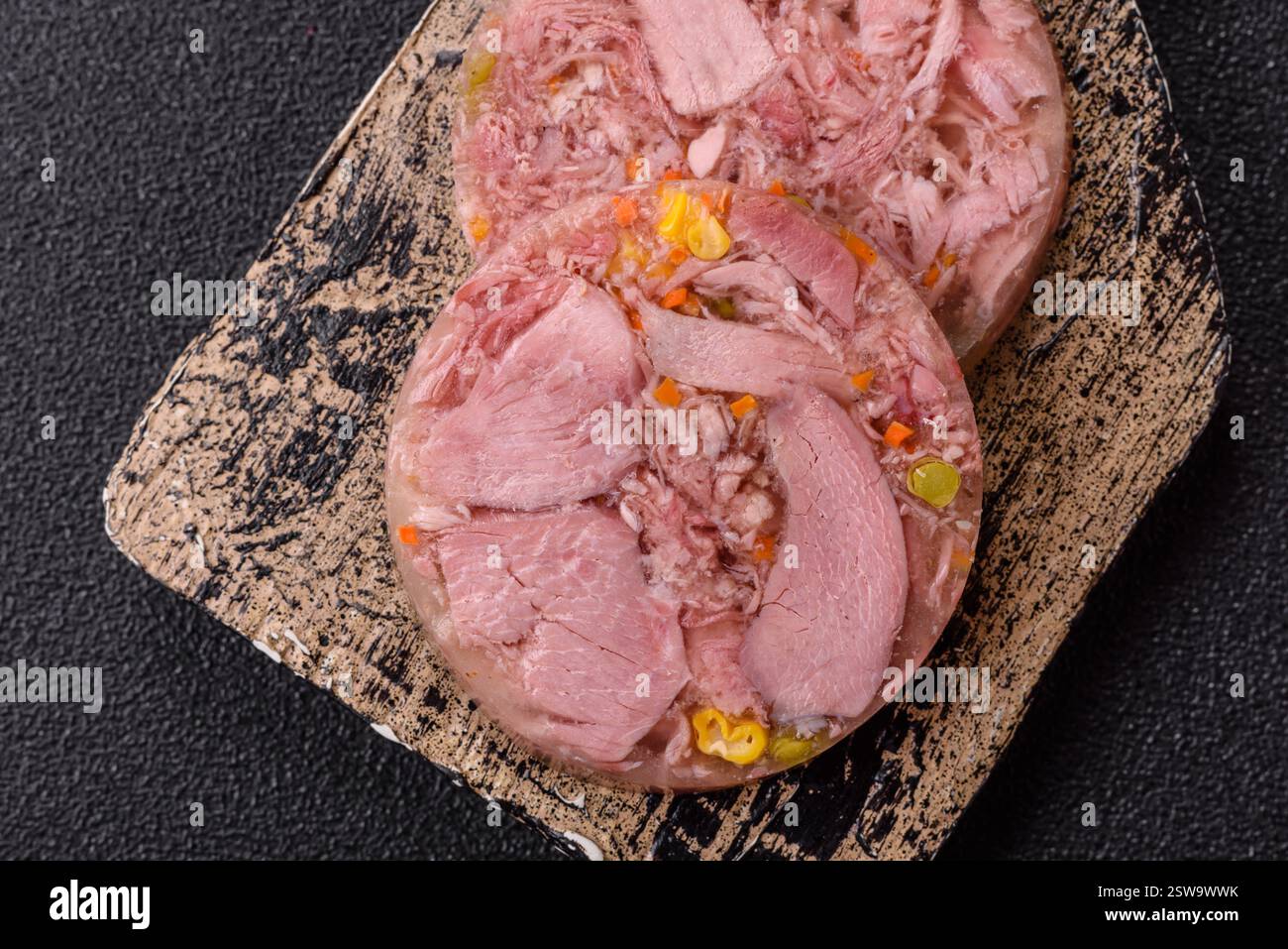 Homemade brawn with salt, spices, herbs and vegetables on a dark ...