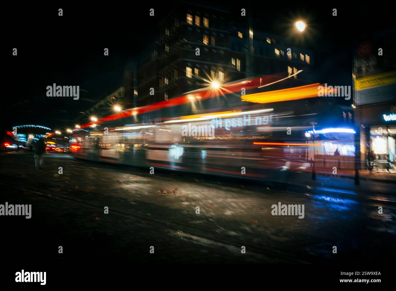 City at night with bus light trails reflecting Den Haag station light ...