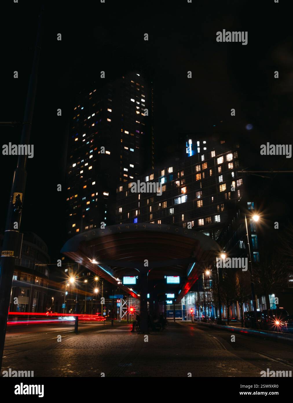 An illuminated city building at night, with glowing windows that reveal ...