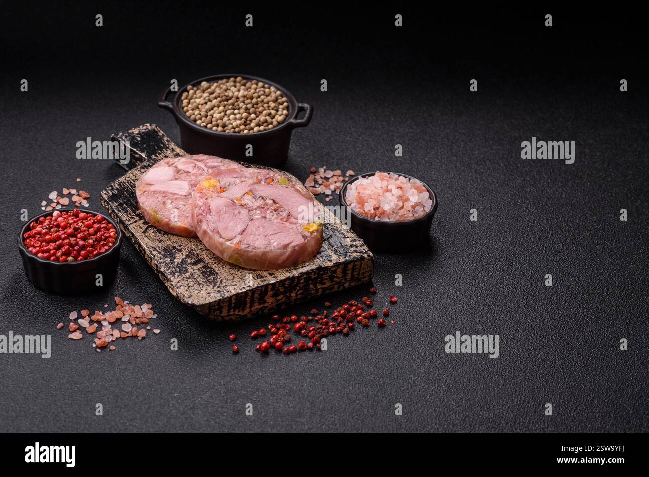 Homemade brawn with salt, spices, herbs and vegetables on a dark ...