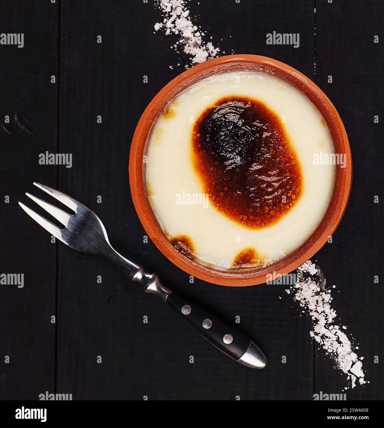 Turkish rice pudding sutlac is being served in an earthenware bowl on ...