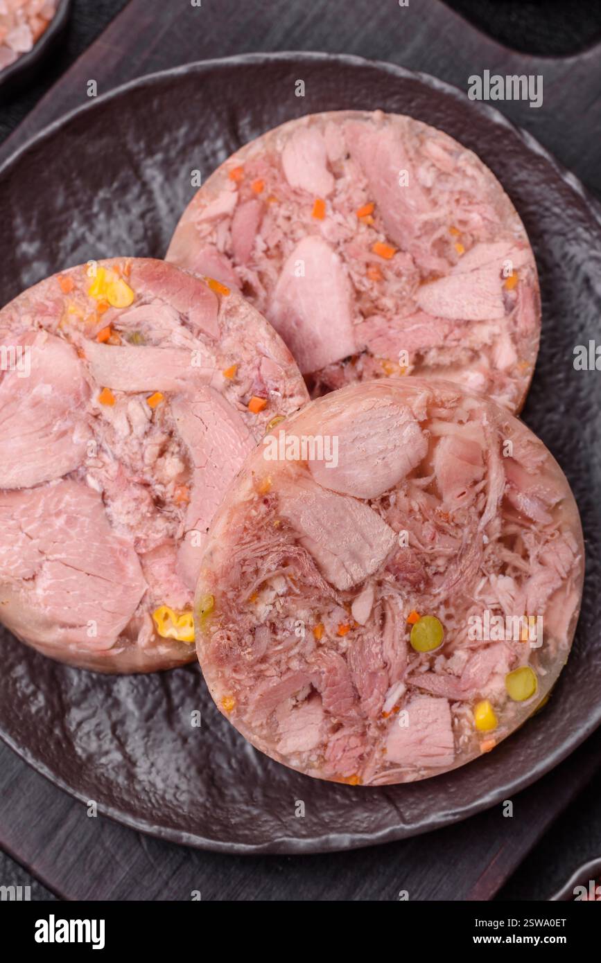 Homemade brawn with salt, spices, herbs and vegetables on a dark ...