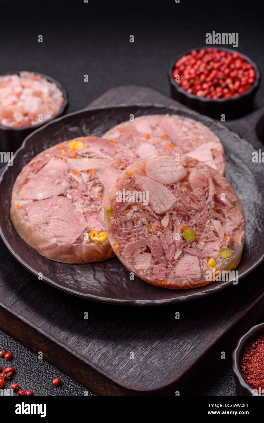 Homemade brawn with salt, spices, herbs and vegetables on a dark ...