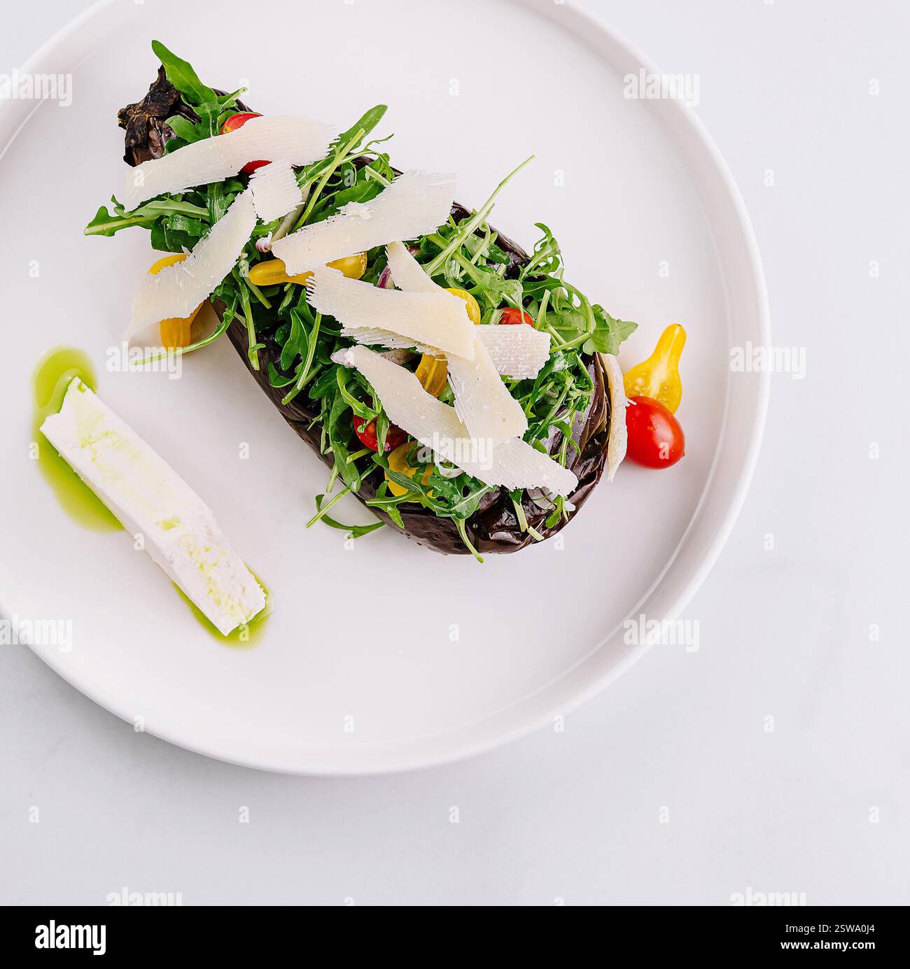 Gourmet salad inside baked eggplant dish on white background Stock ...
