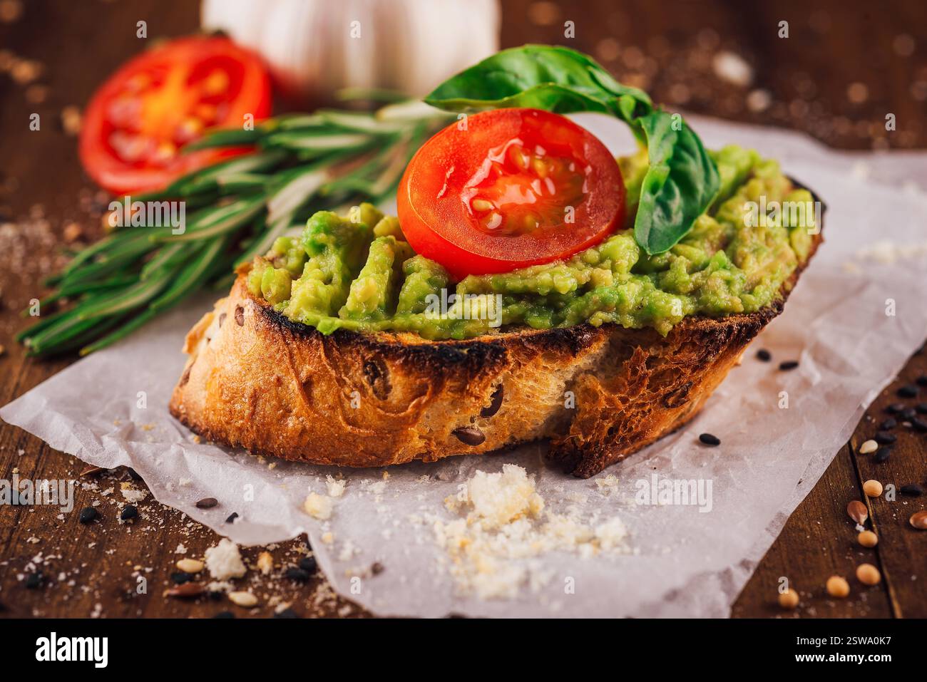 Toasted multigrain bread with avocado spread, cherry tomato and basil ...