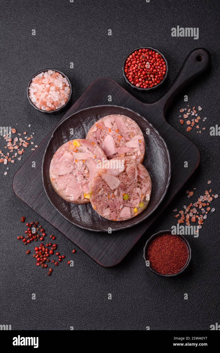 Homemade brawn with salt, spices, herbs and vegetables on a dark ...