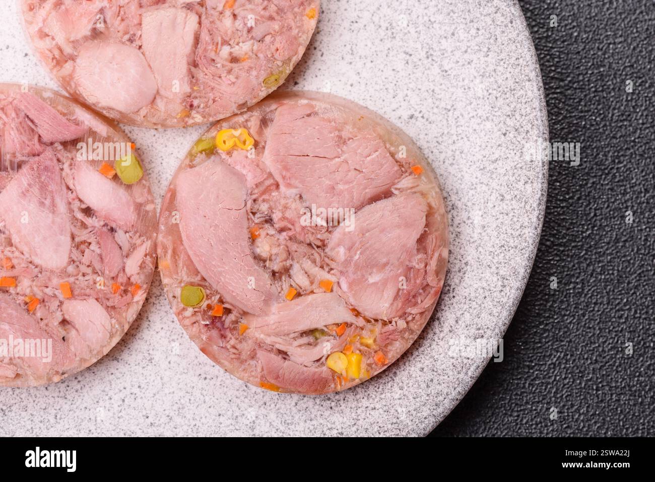 Homemade brawn with salt, spices, herbs and vegetables on a dark ...