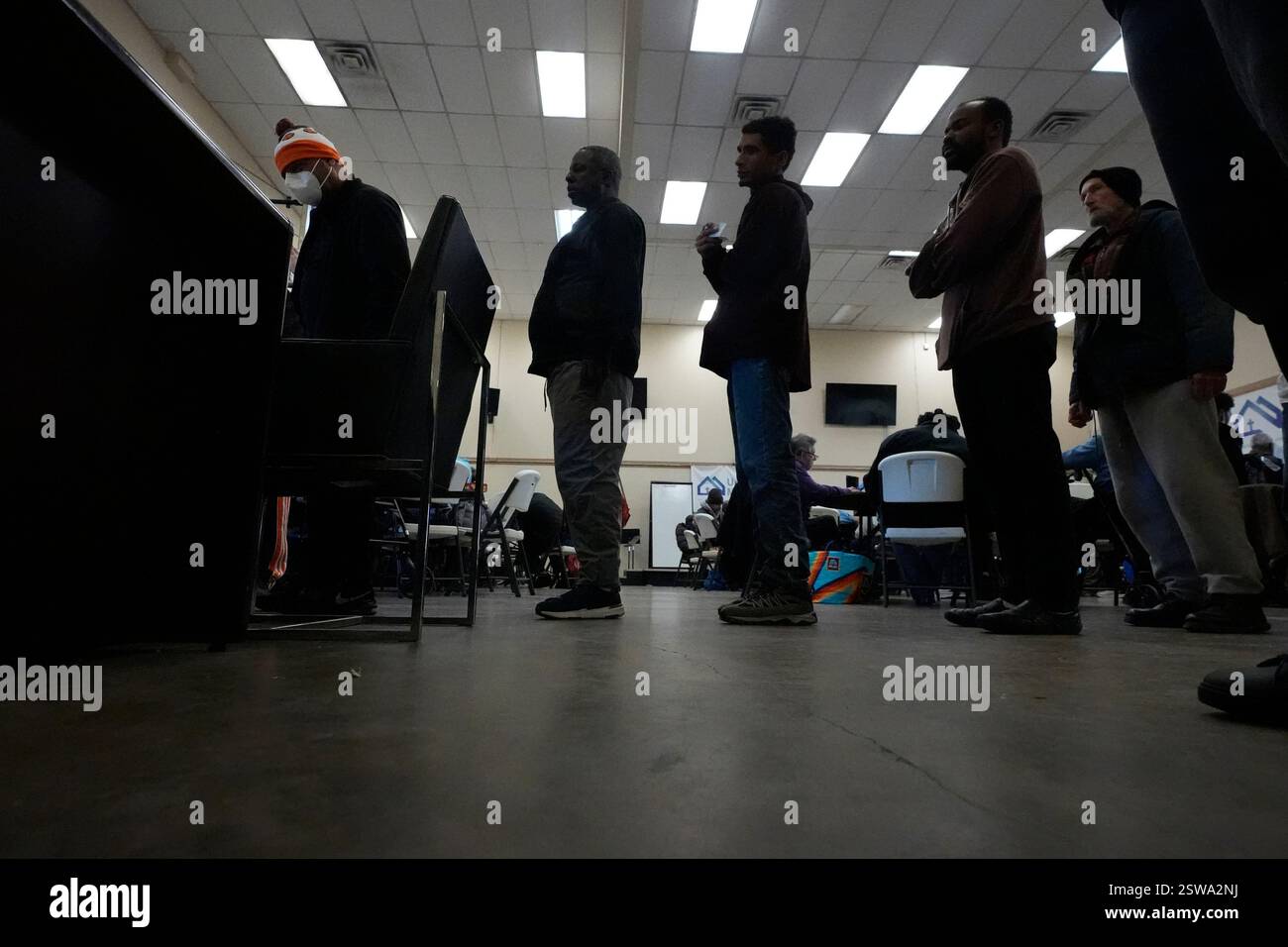 Men wait in line for an overnight bed ticket at the Union Gospel ...