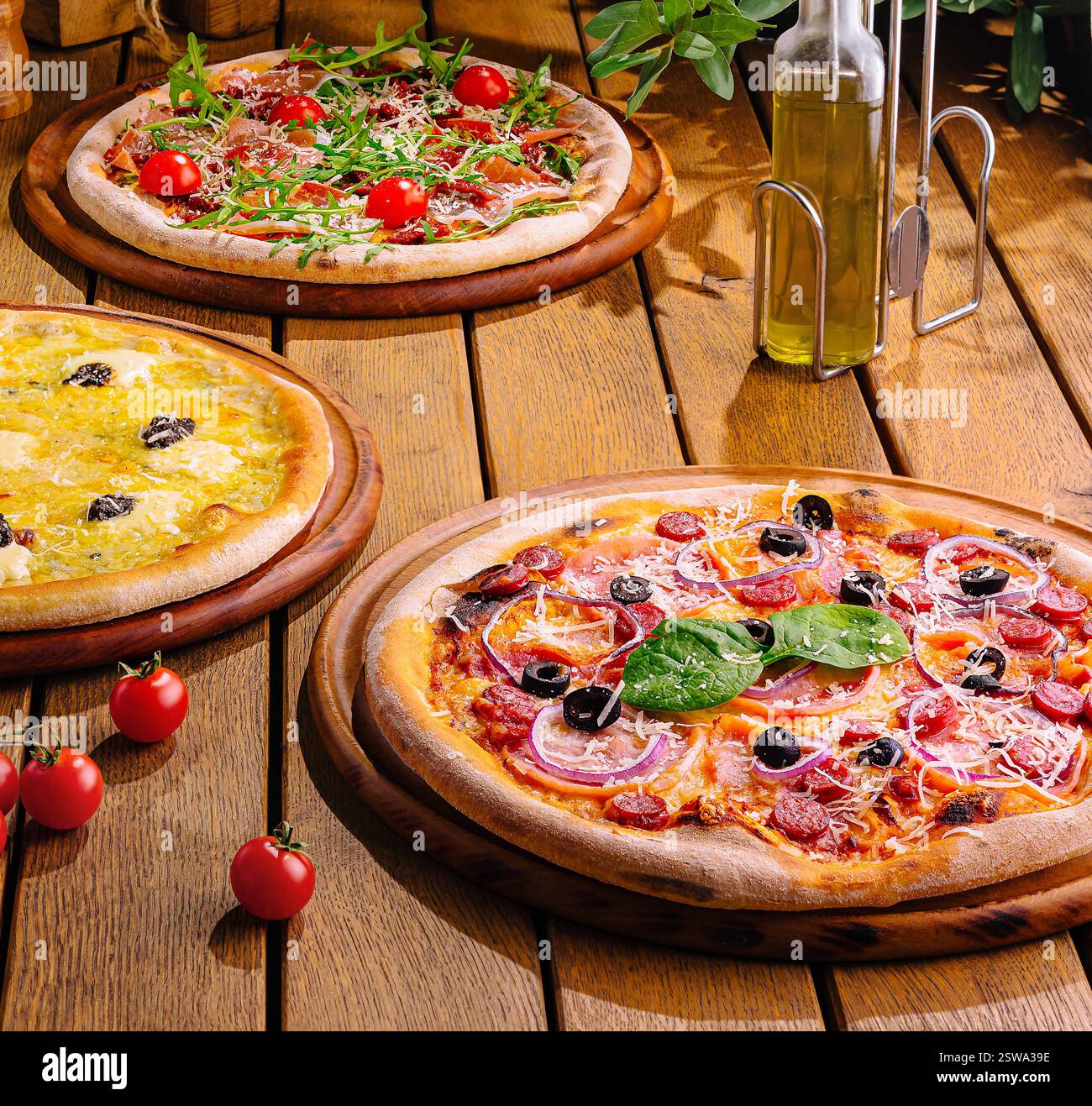 Delicious variety of pizzas on a cozy setup Stock Photo - Alamy