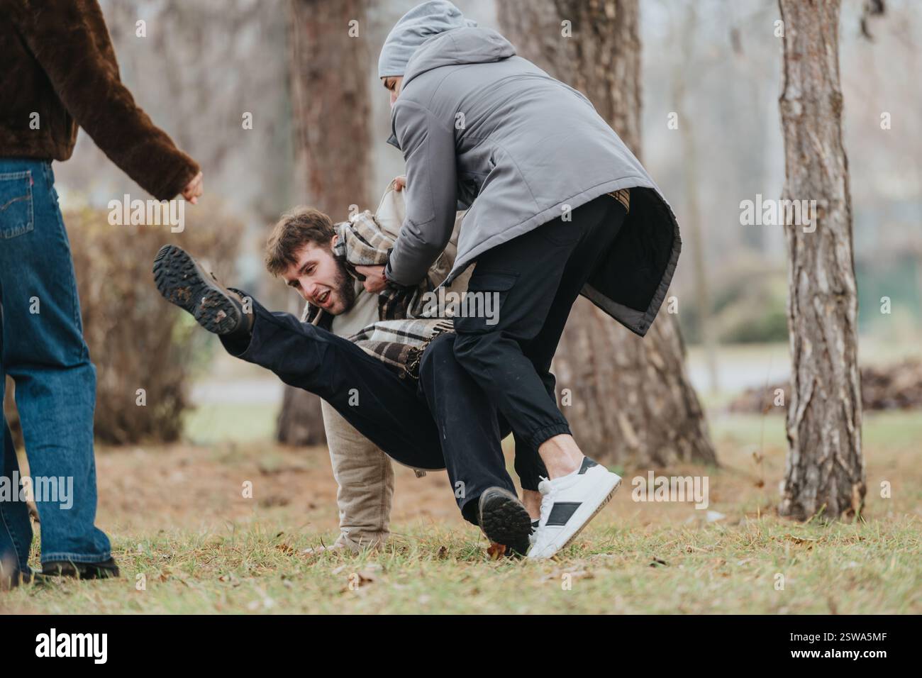 A Group of People Engaged in a Struggle in a Park Setting Stock Photo ...