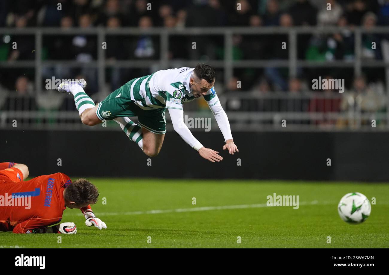 Shamrock Rovers' Aaron McEneff hurdles Molde goalkeeper Jacob Karlstrom ...