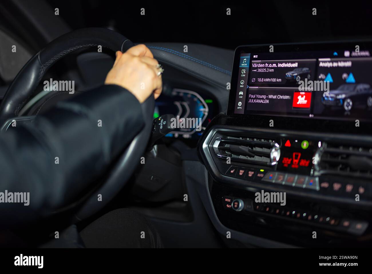 Close-up view of driver holding steering wheel of BMW iX3 electric ...