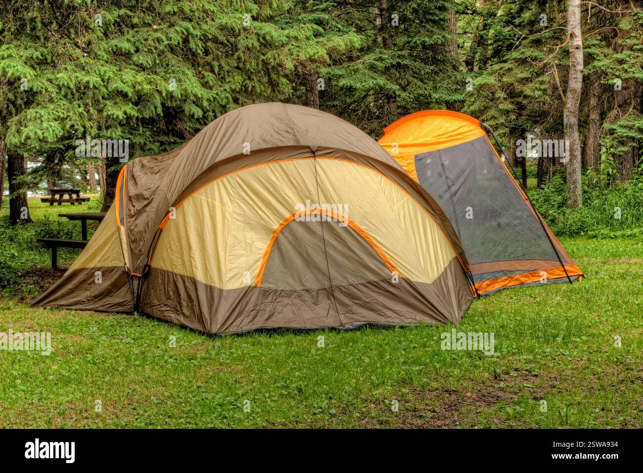 Tent is set up in a grassy field. The tent is a large, brown and tan ...