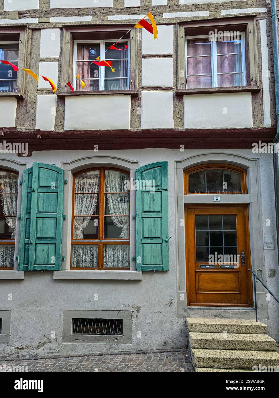 View of part of a medieval half-timbered house, windows with curtains ...