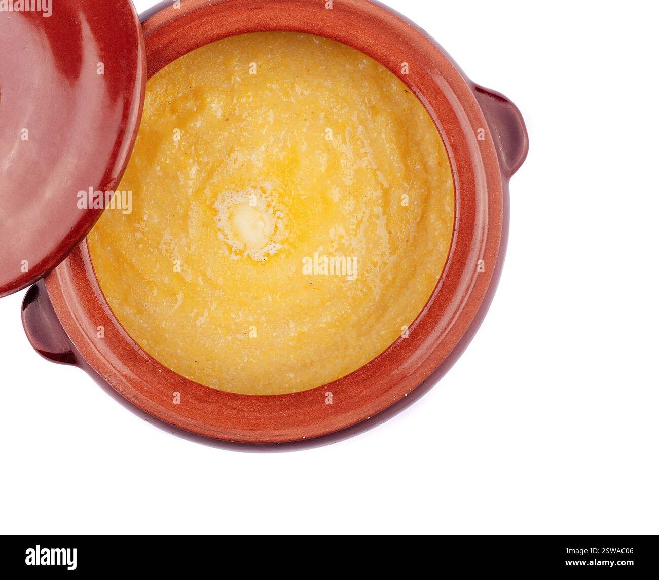 Opened clay pot with hot polenta and melting butter inside Stock Photo ...