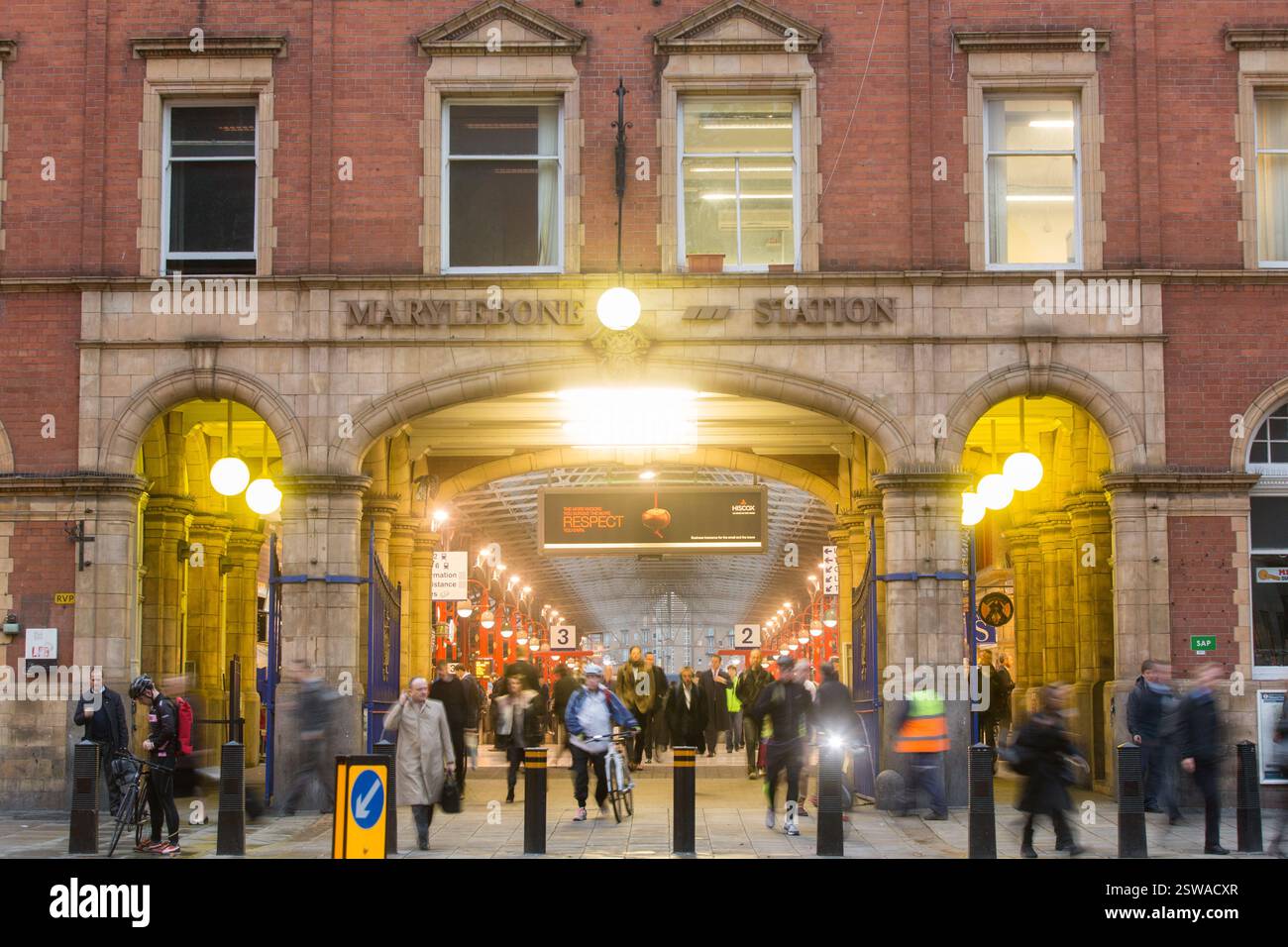 Pedestrians at Marylebone Station, London, UK. Commuters navigate the station's arched entrance ...