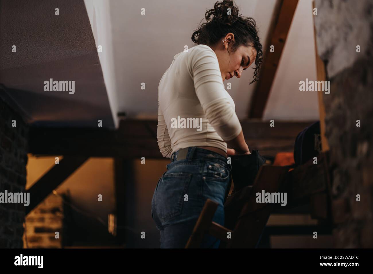 Woman organizing personal items in a cozy, rustic home setting Stock ...