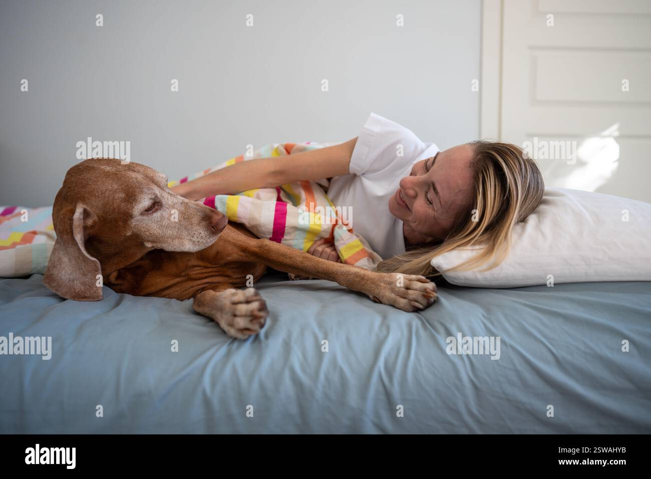 Happy smiling female owner and pet dog enjoying pleasant morning time ...