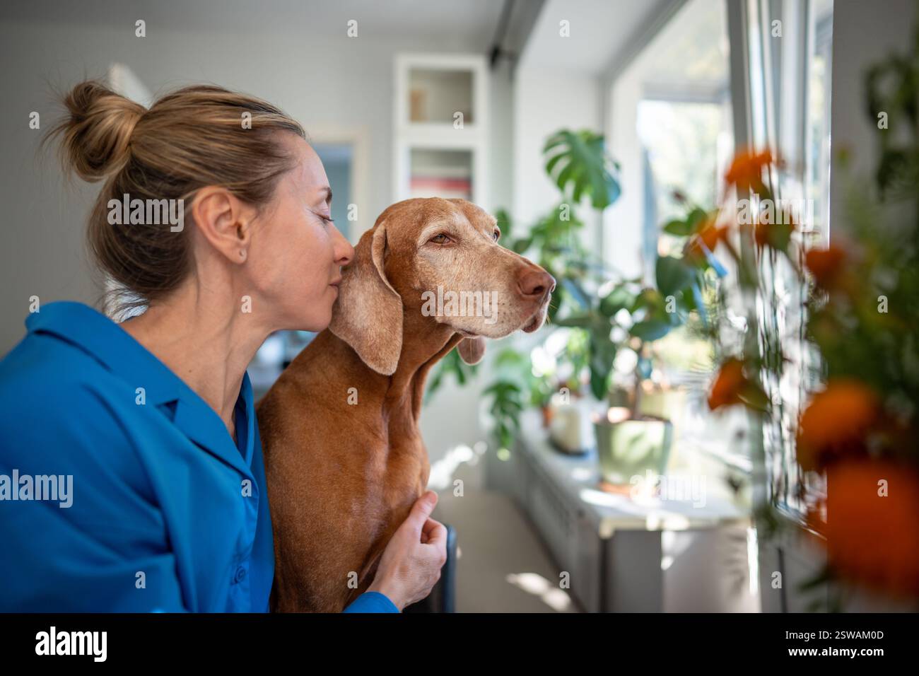Tired woman cuddles with happy cute dog at home. Exhausted female take ...