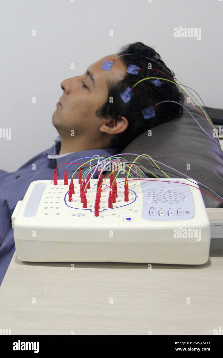Electroencephalogram EEG in adult Latino man with wires in his head ...