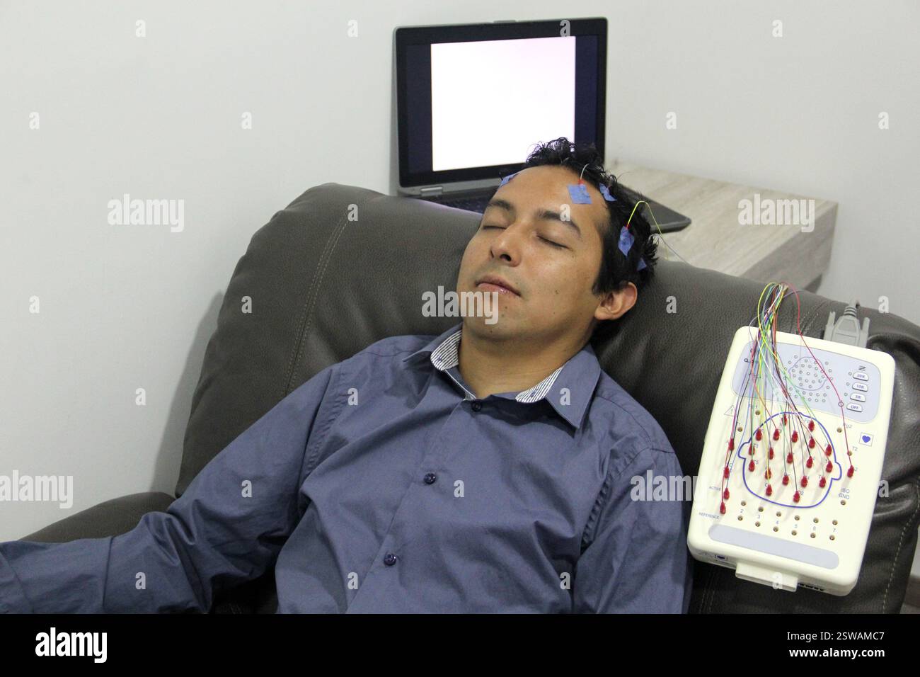 Electroencephalogram EEG in adult Latino man with wires in his head ...