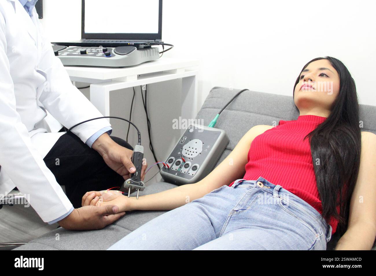 Latin female patient undergoes a neurological study, electromyography ...