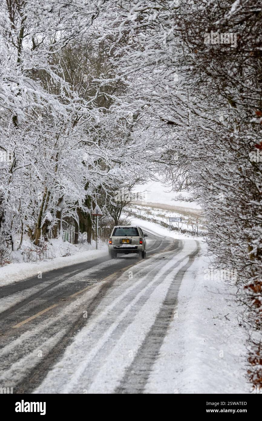 The A684 between Hawes and Sedbergh with the road and tress covered in ...