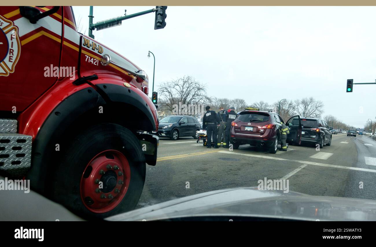 Fire truck, firemen, paramedic assisting at scene of an automobile ...