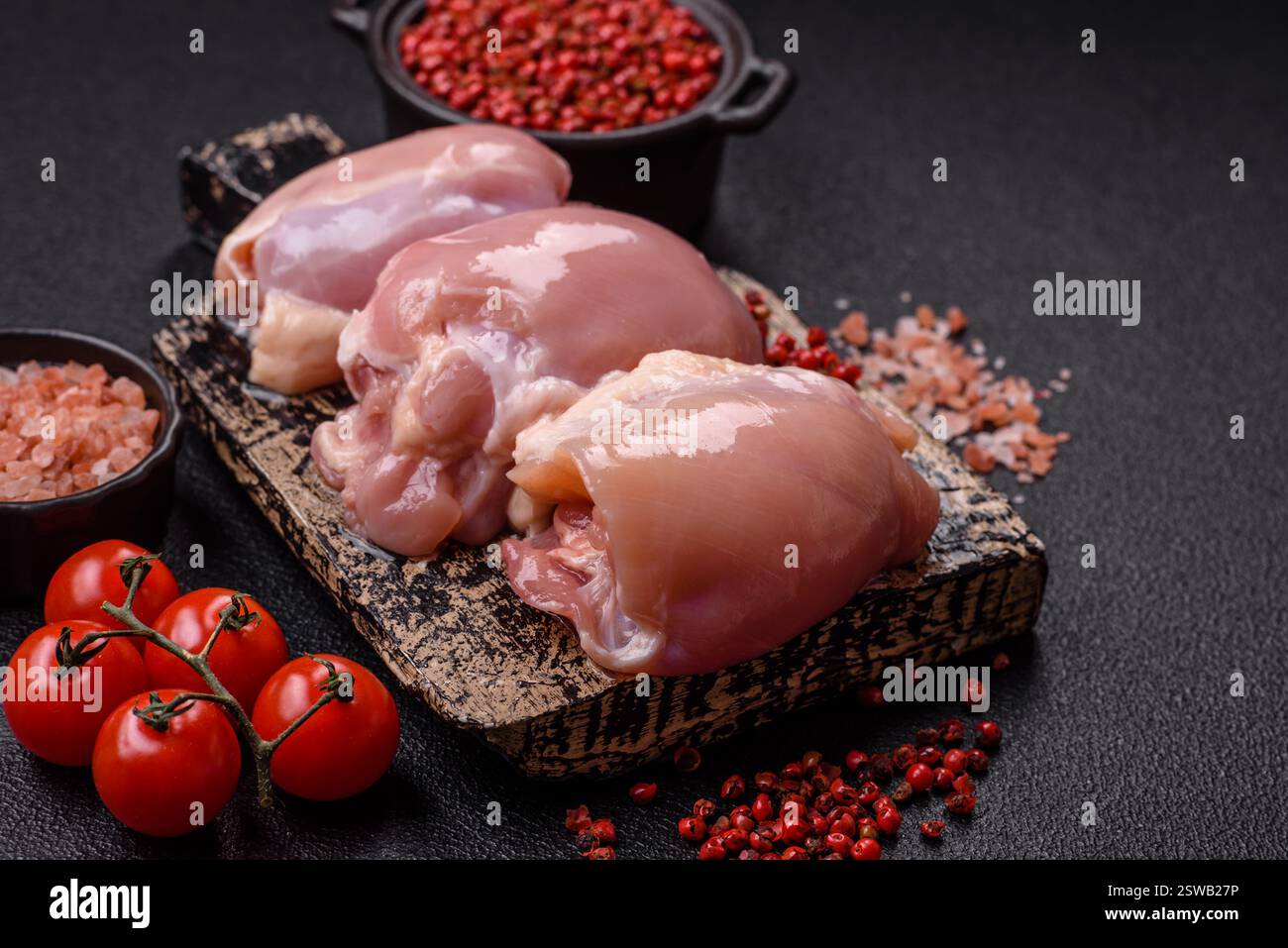 Fresh raw chicken thigh fillets with salt, spices and herbs Stock Photo ...