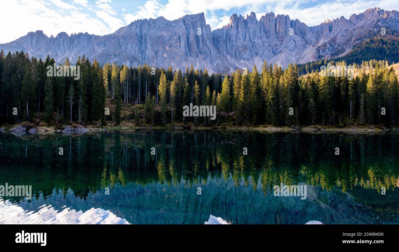 A tranquil dawn at a pristine lake surrounded by towering Dolomites in ...