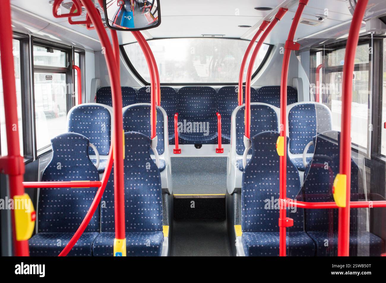 Interior of a double-decker bus, likely in London, UK. Empty seats with ...