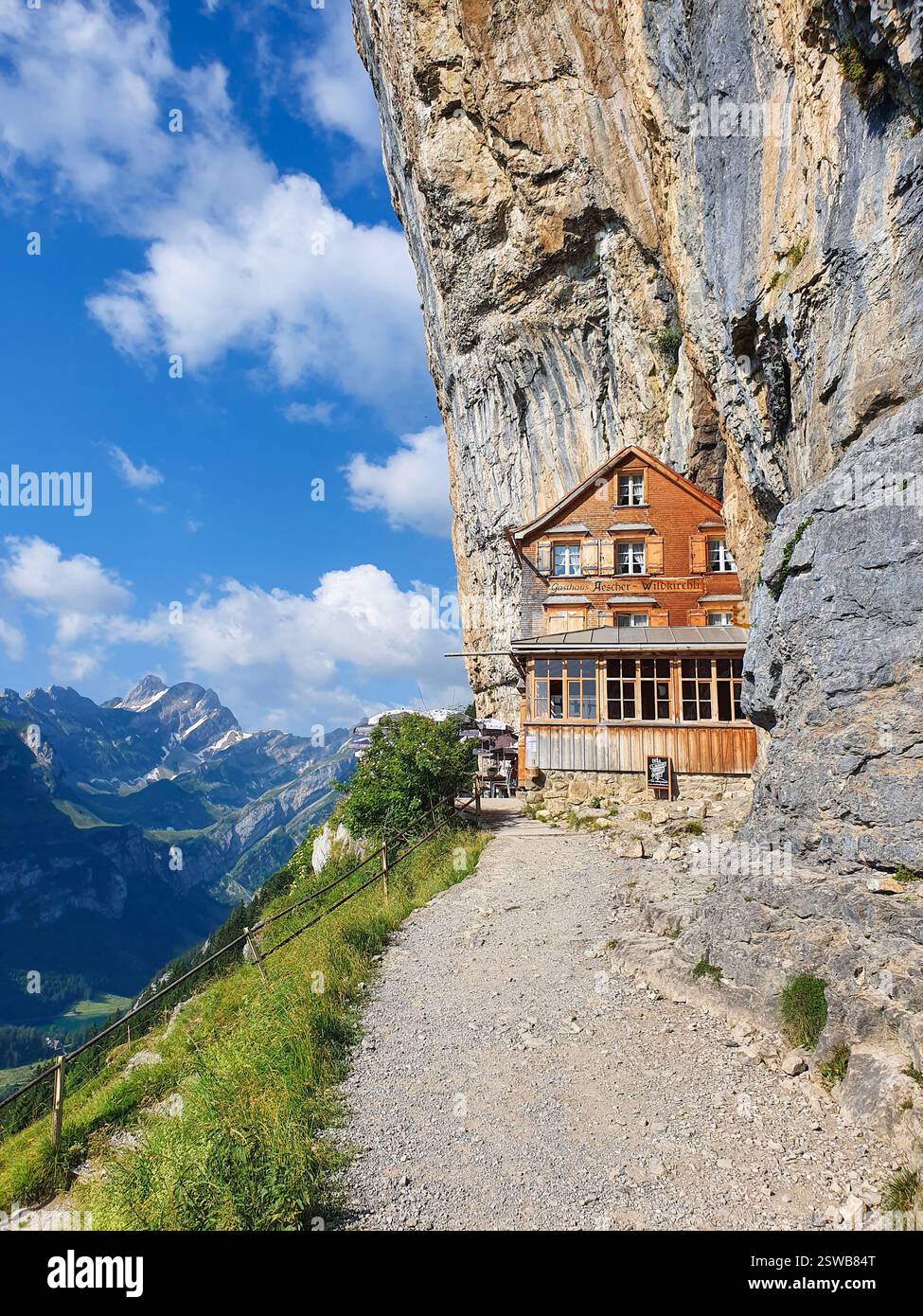 A charming wooden lodge nestled beneath towering cliffs in a ...
