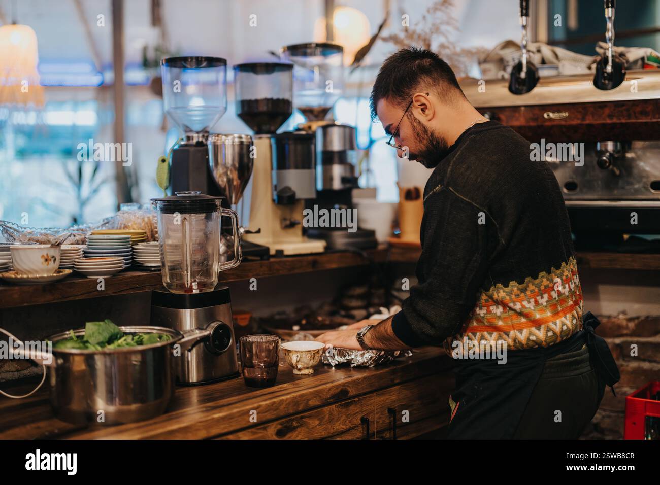 Barista preparing coffee in a cozy coffee shop with modern equipment Stock Photo - Alamy