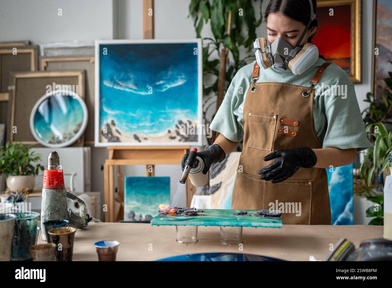 Female artist burn epoxy resin painting with blowtorch hi-res stock ...