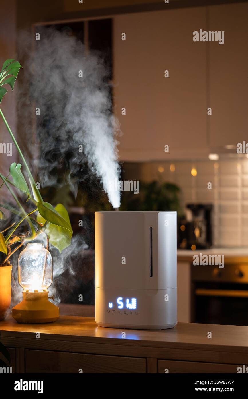 Air humidifier stand on wooden chest of drawers at home, steam ...