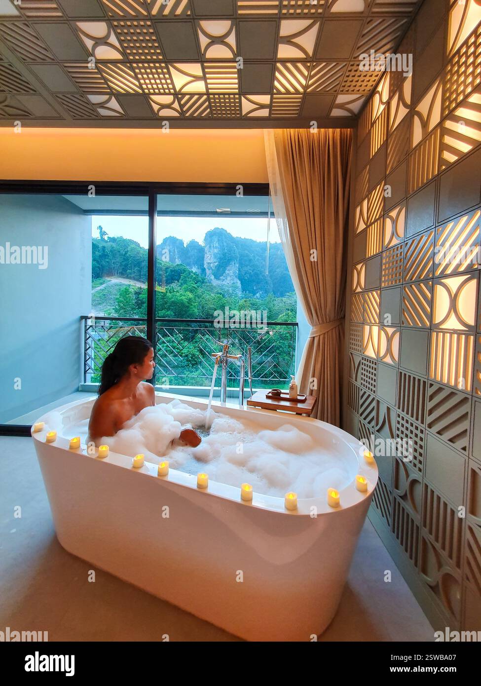 A luxurious bathtime view from a modern hillside spa retreat, surrounded by nature at twilight ...