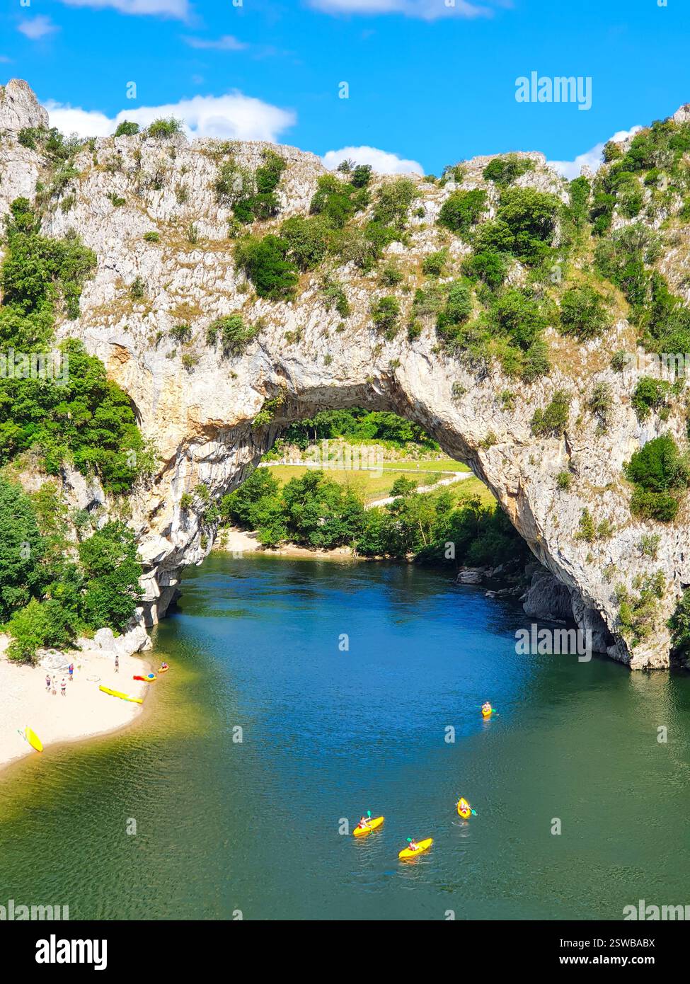 A stunning limestone arch towers magnificently above a tranquil river ...
