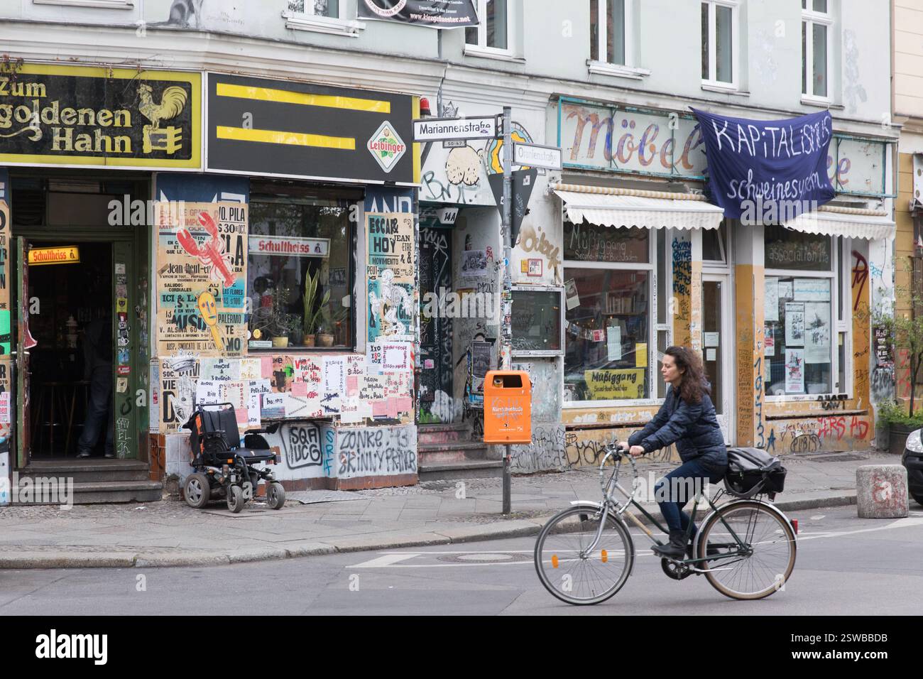Pedestrian on bicycle, Marienstraße, Berlin. Graffiti-covered buildings ...