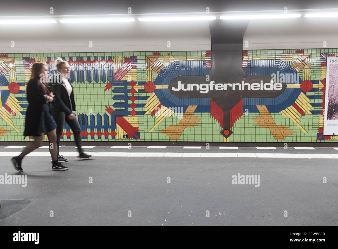 Pedestrians walk past the colorful tile mural at the Jungfernheide ...
