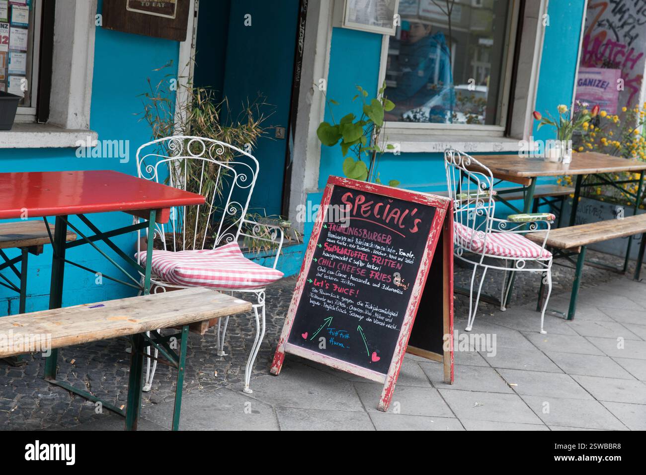 Outdoor cafe in Berlin, Friedrichshain, featuring a menu board with ...