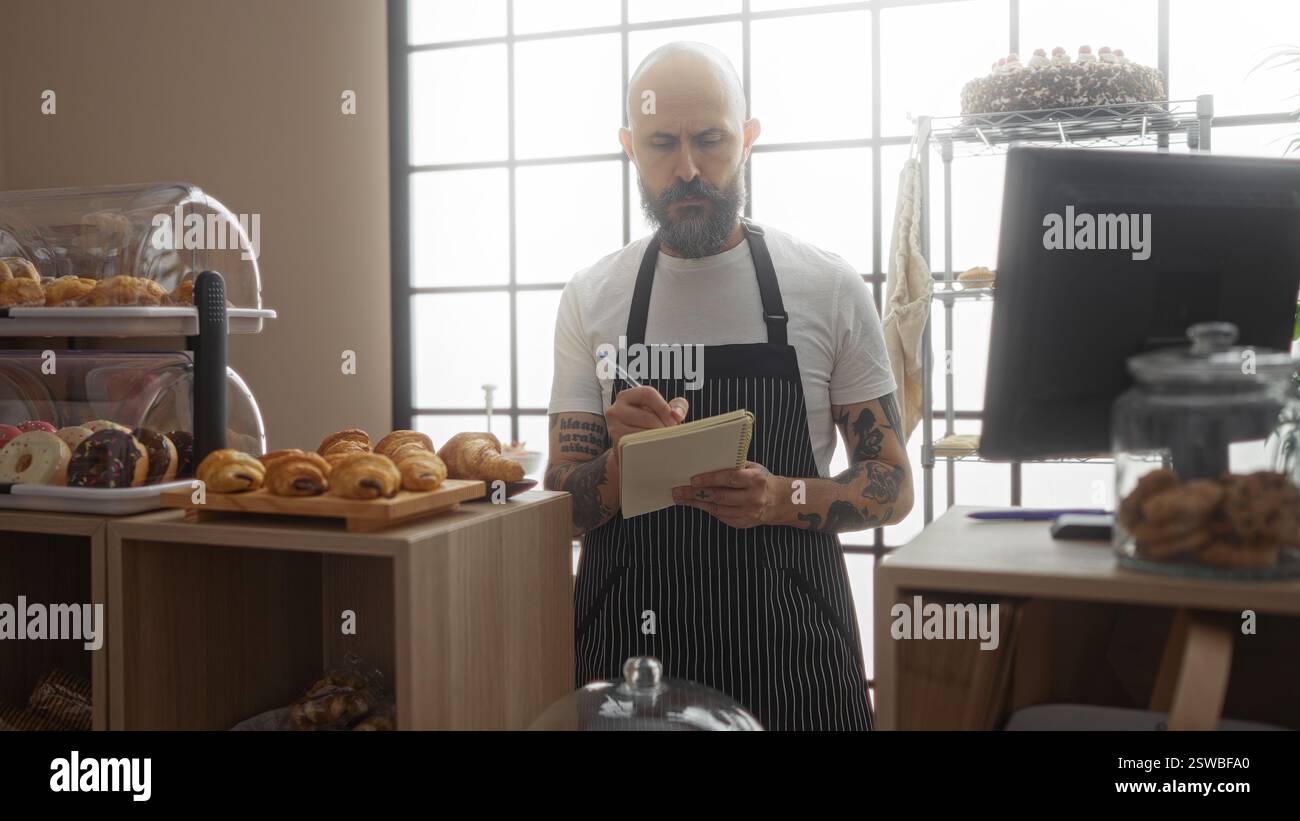 Hispanic man with a beard in a bakery interior, writing notes while ...