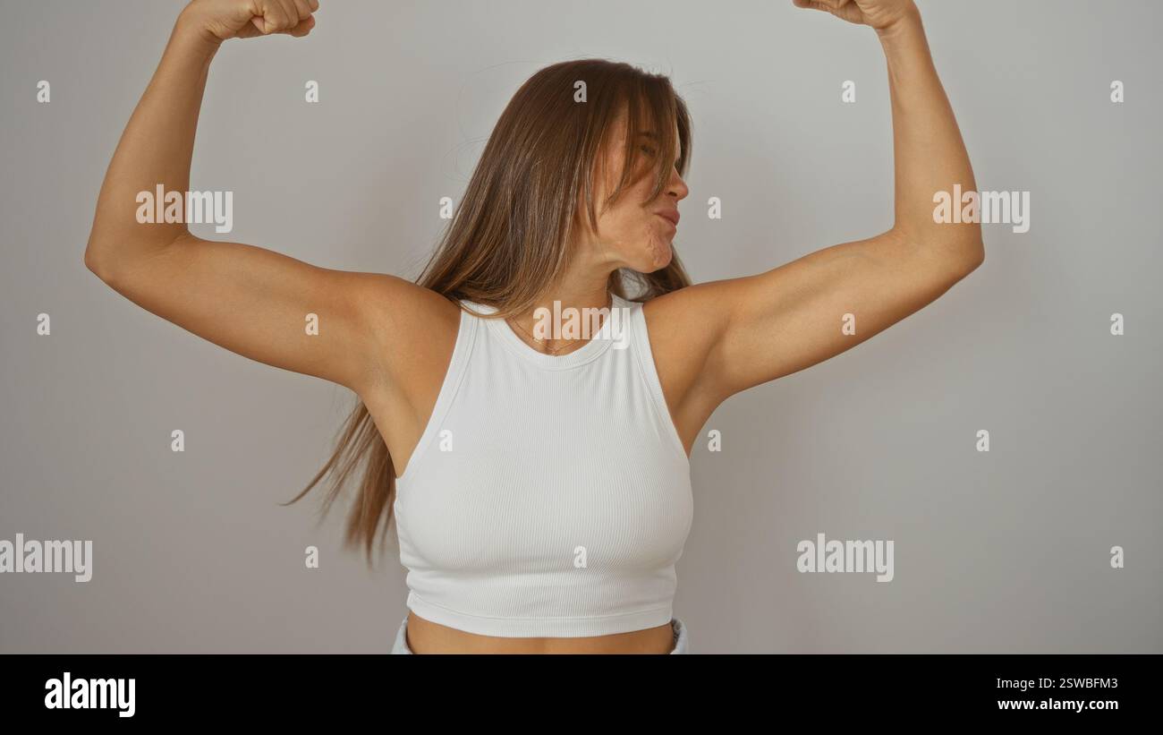 Young attractive hispanic woman flexing muscles isolated over white ...