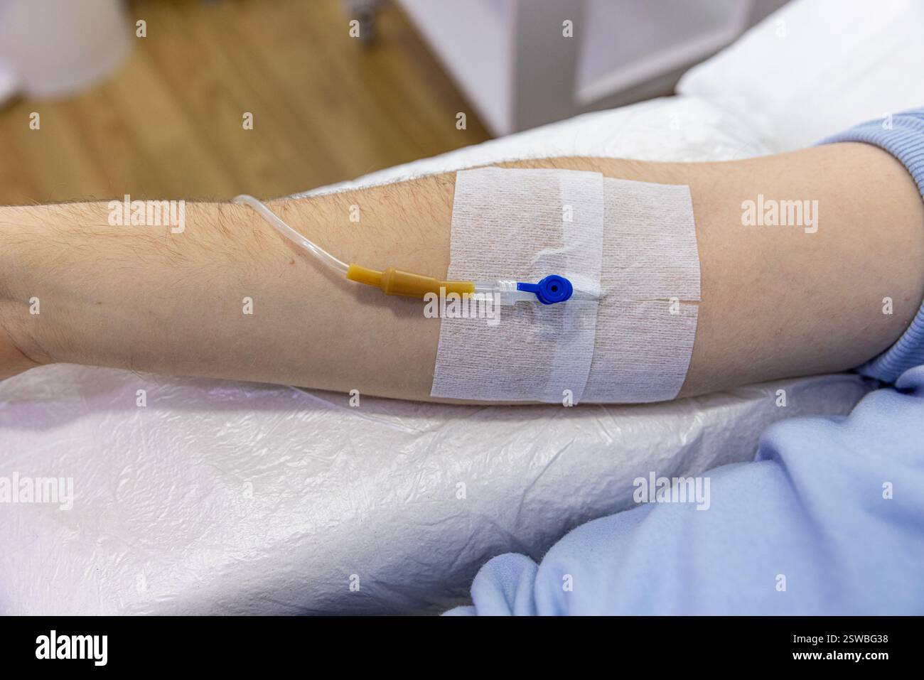 The doctor inserts a needle into the vein of the patient. Nurse connecting an IV drip. Nurse ...
