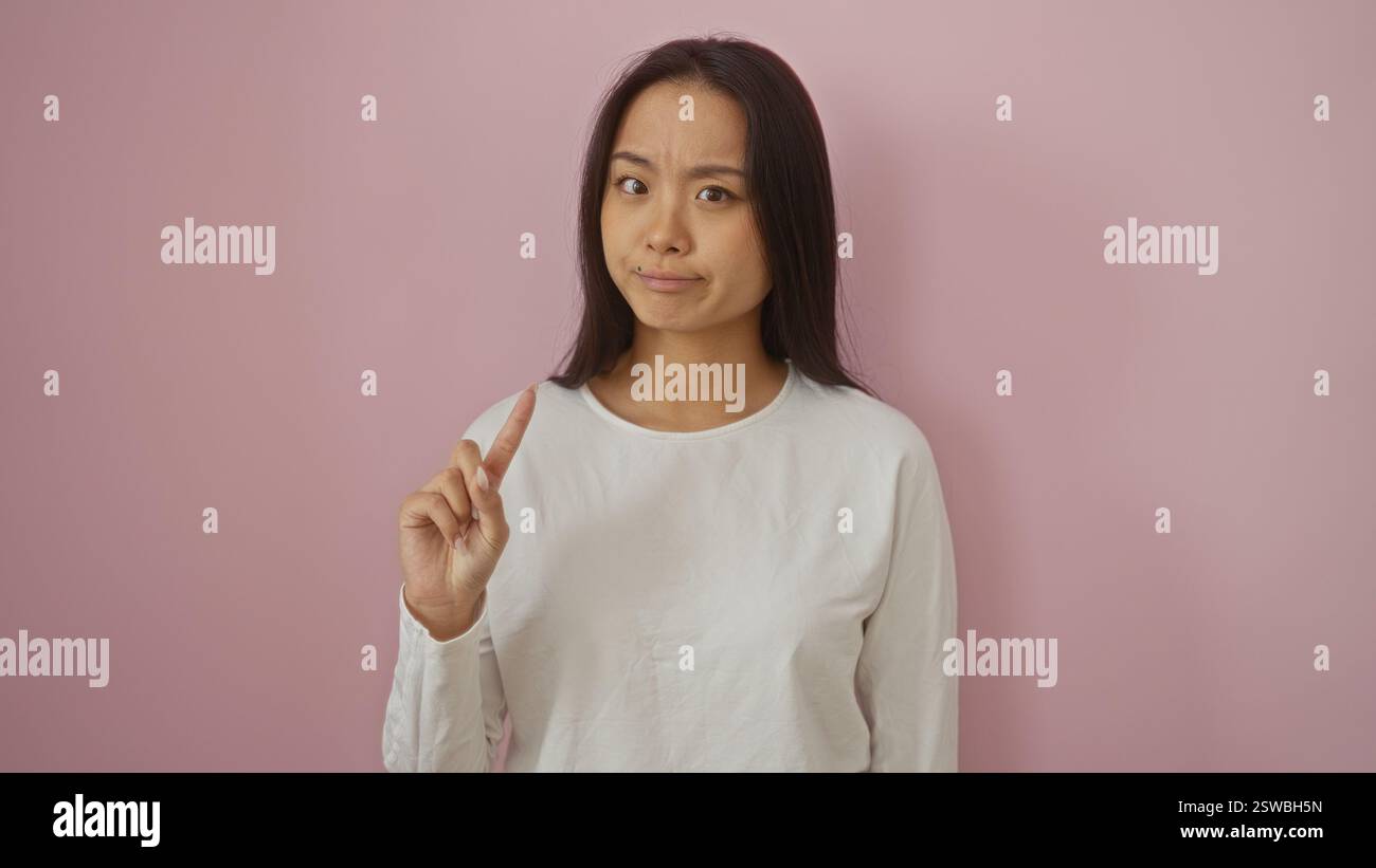 Woman gesturing no with finger against pink background, young and ...