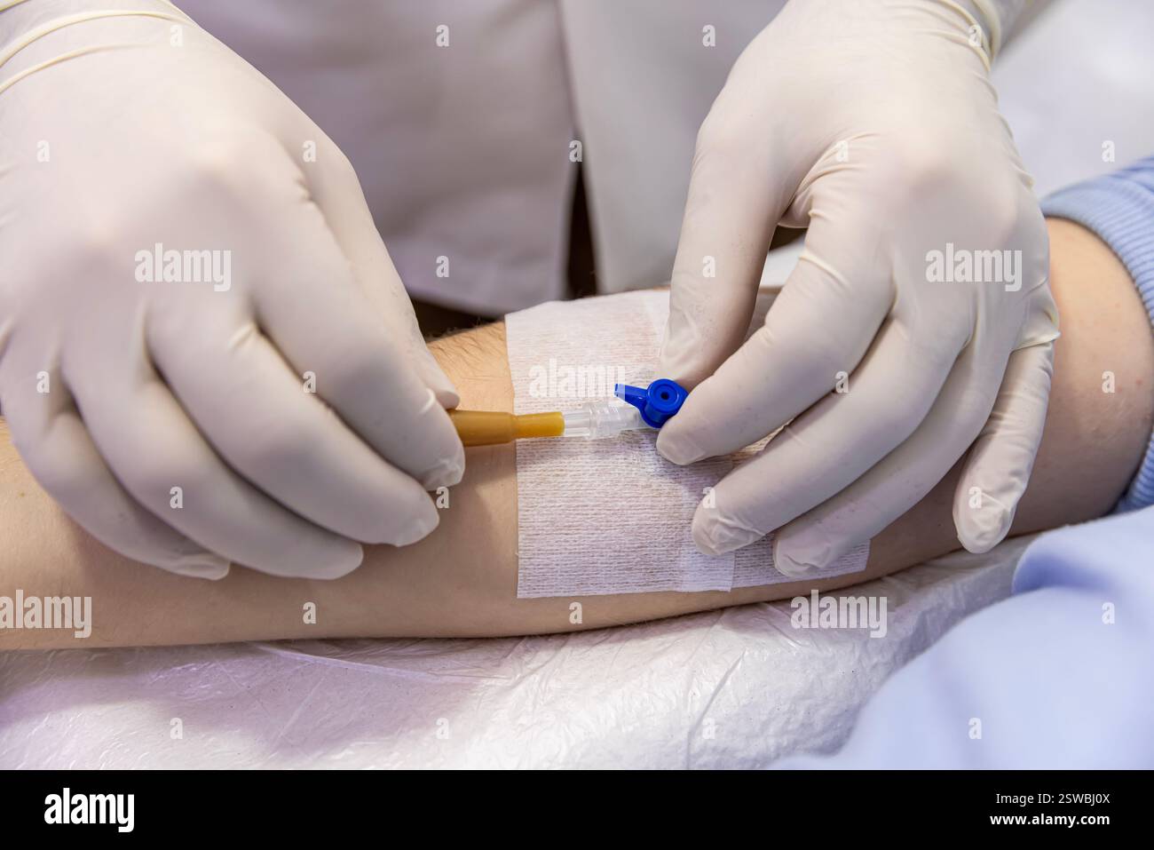 The doctor inserts a needle into the vein of the patient. Nurse ...