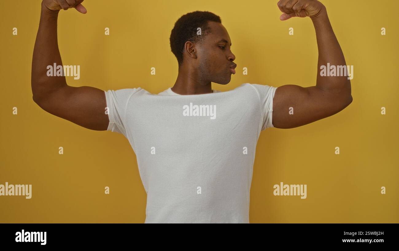 Young man flexing muscles against isolated yellow background ...