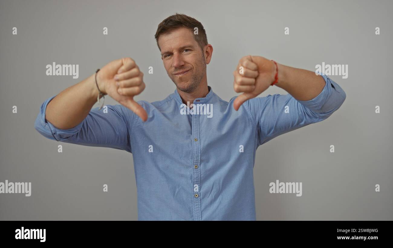Young man showing thumbs down gesture against isolated white background ...